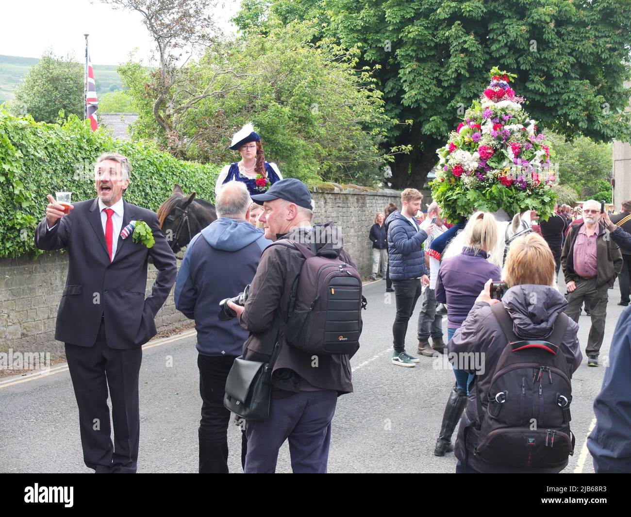 The Castleton Garland King wearing a hooped garland of flowers rides on ...