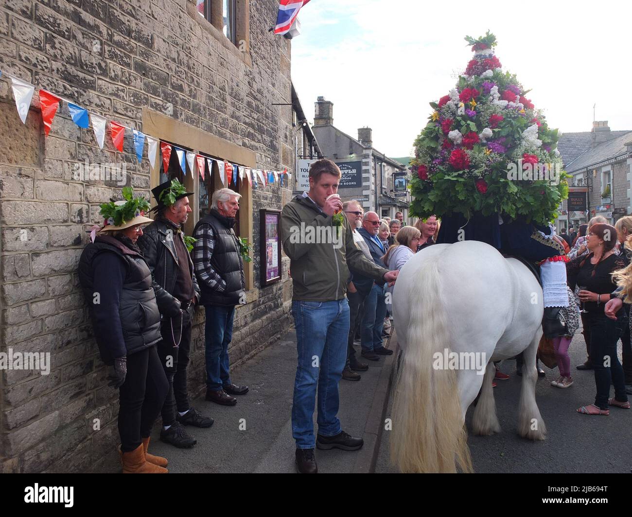 The Castleton Garland King wearing a hooped garland of flowers rides on ...