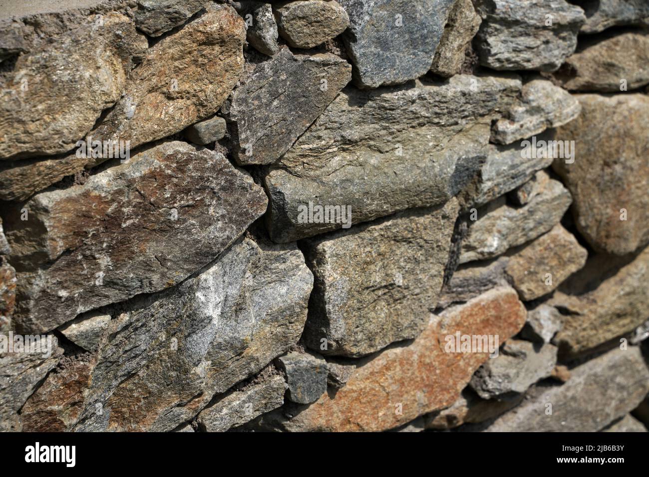 Natural stone wall in a garden Stock Photo - Alamy