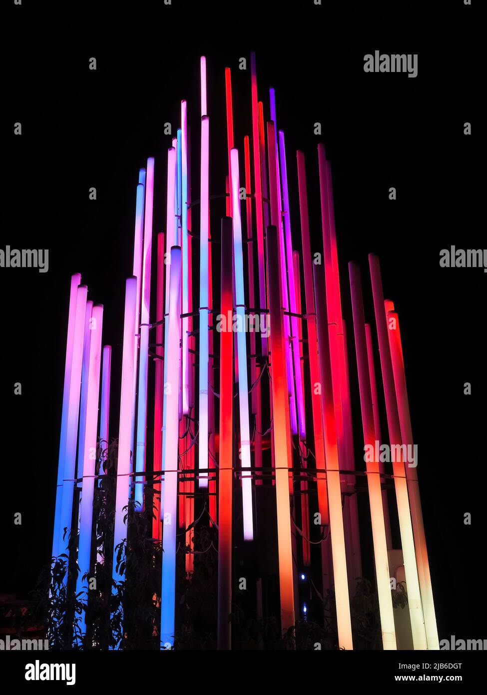 A bright colored luminous installation illuminates the park at night ...