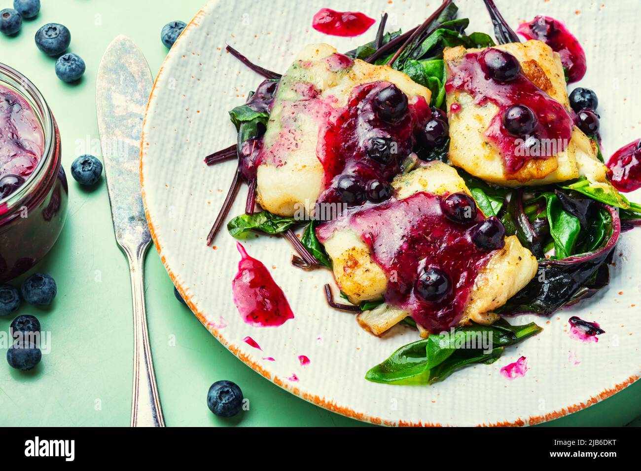 Delicious baked fish with berry sauce. Stewed pangasius with ...