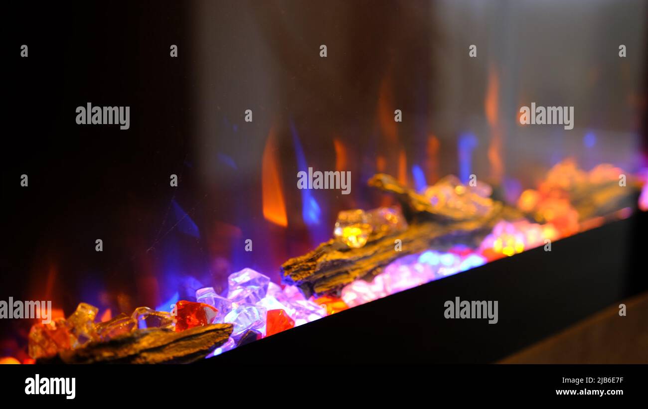 Side view on electric fireplace with artificial sparkling flame, decor ...