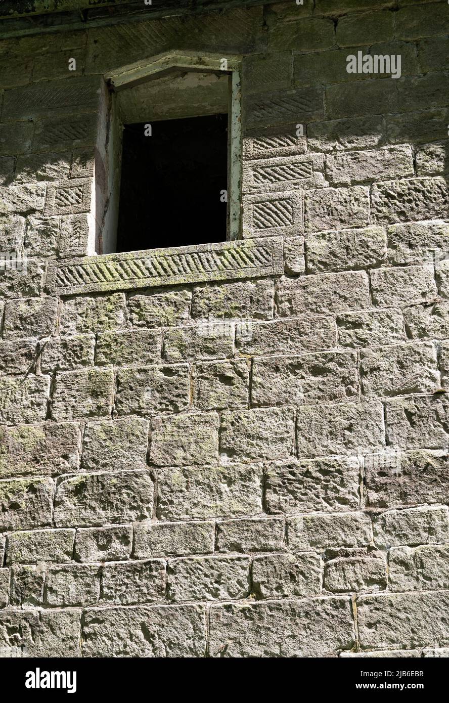 Historic stone wall with decorative carved window opening and weathered ...