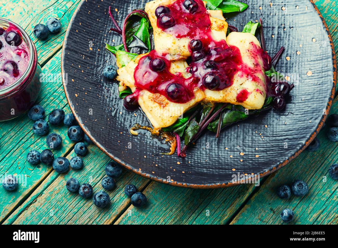 Delicious baked fish with berry sauce. Stewed pangasius with ...