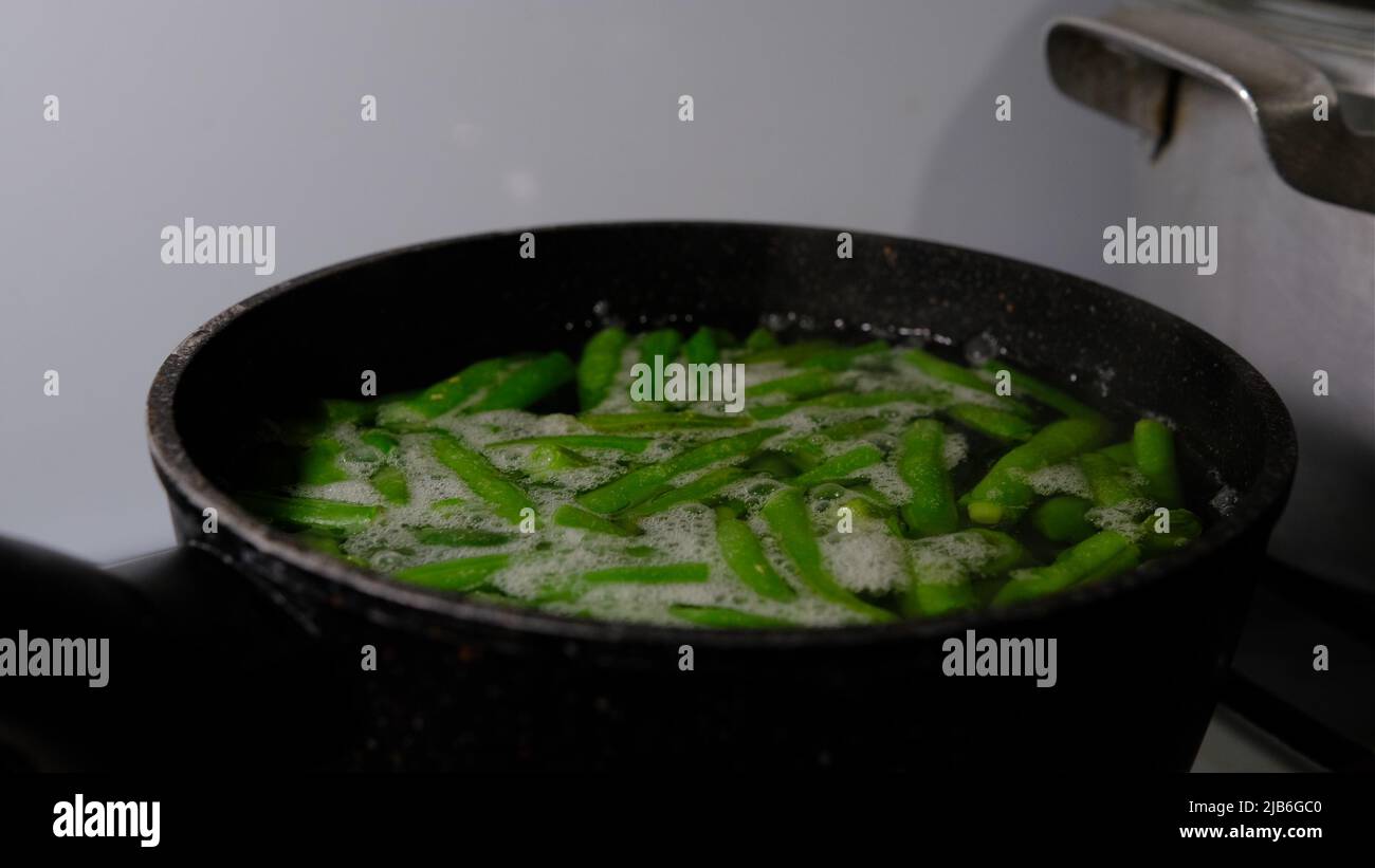Close-up on boiling the green beans in a pot with boiling water and ...