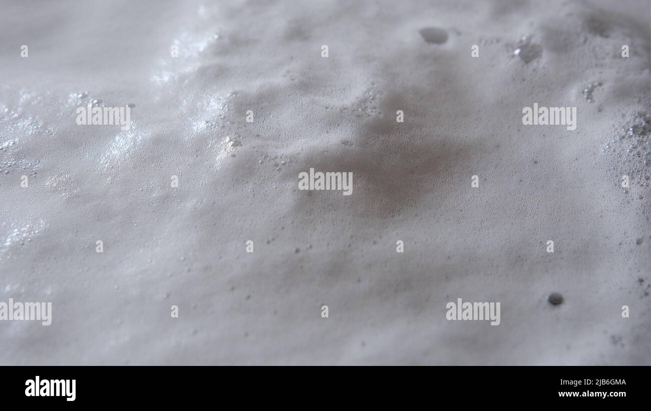 Steam or vapor clouds rising from boiling water with clotted foam and ...