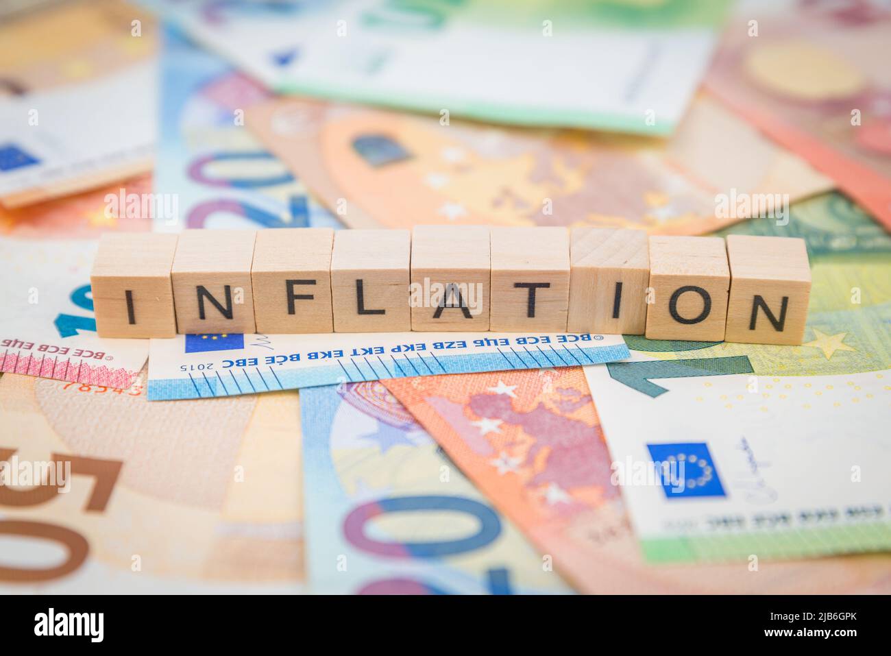 The word inflation written on banknotes Euro banknotes with wooden cube ...