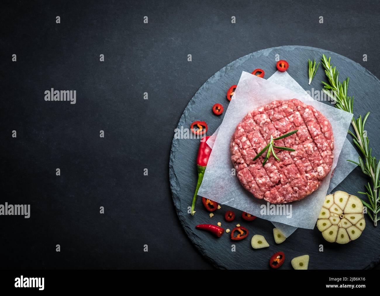 Raw burger beef patty on stone background Stock Photo - Alamy