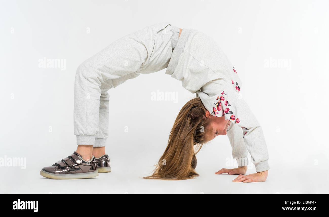 Little girl do bridge position on light background Stock Photo - Alamy