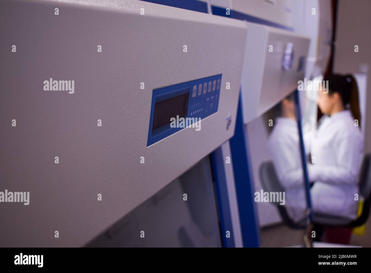 Woman researcher works in a hepa filtered cabin inside a cell tissue ...
