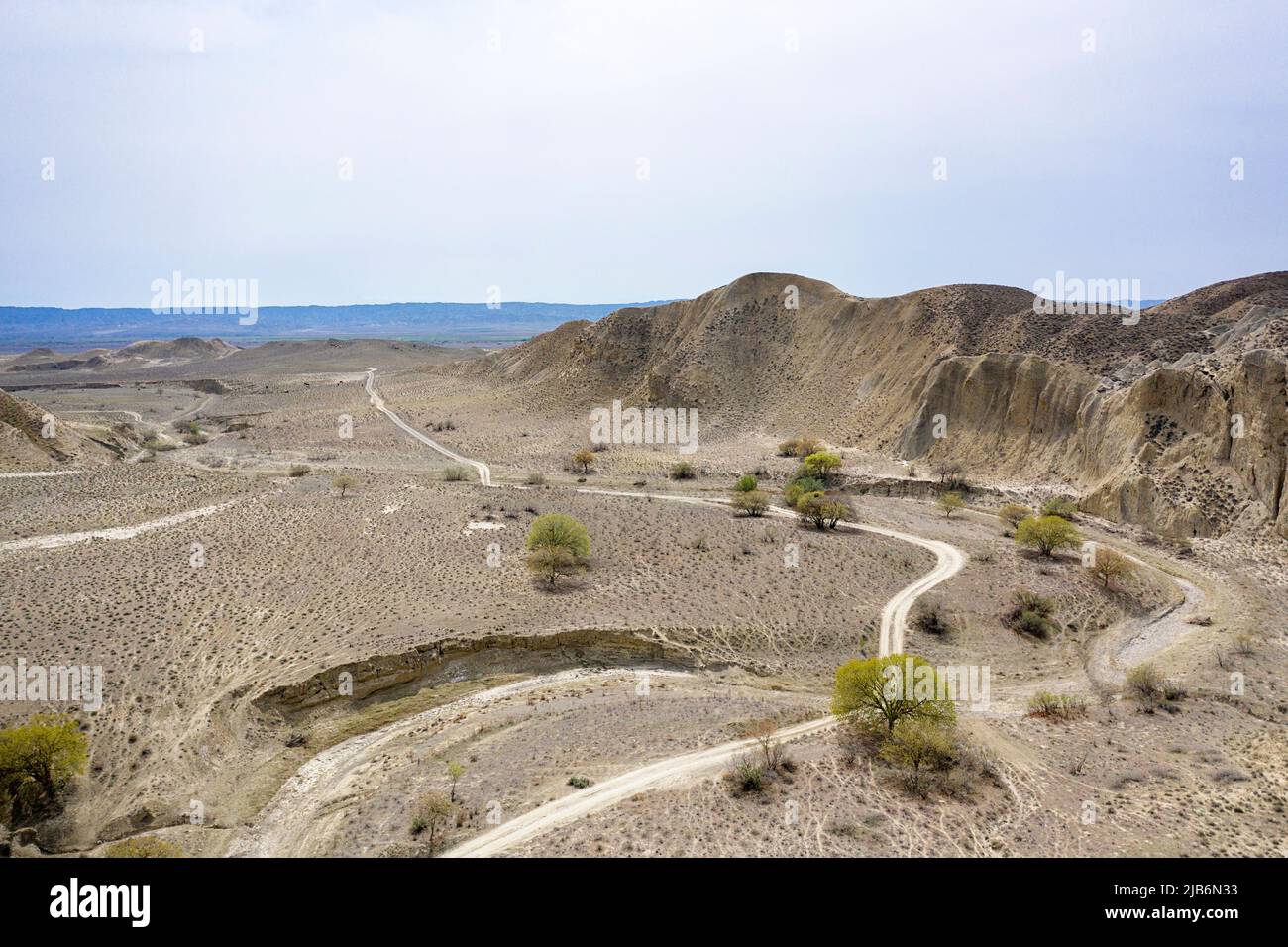 Gravel road winding through spectacular desert like landscape in ...