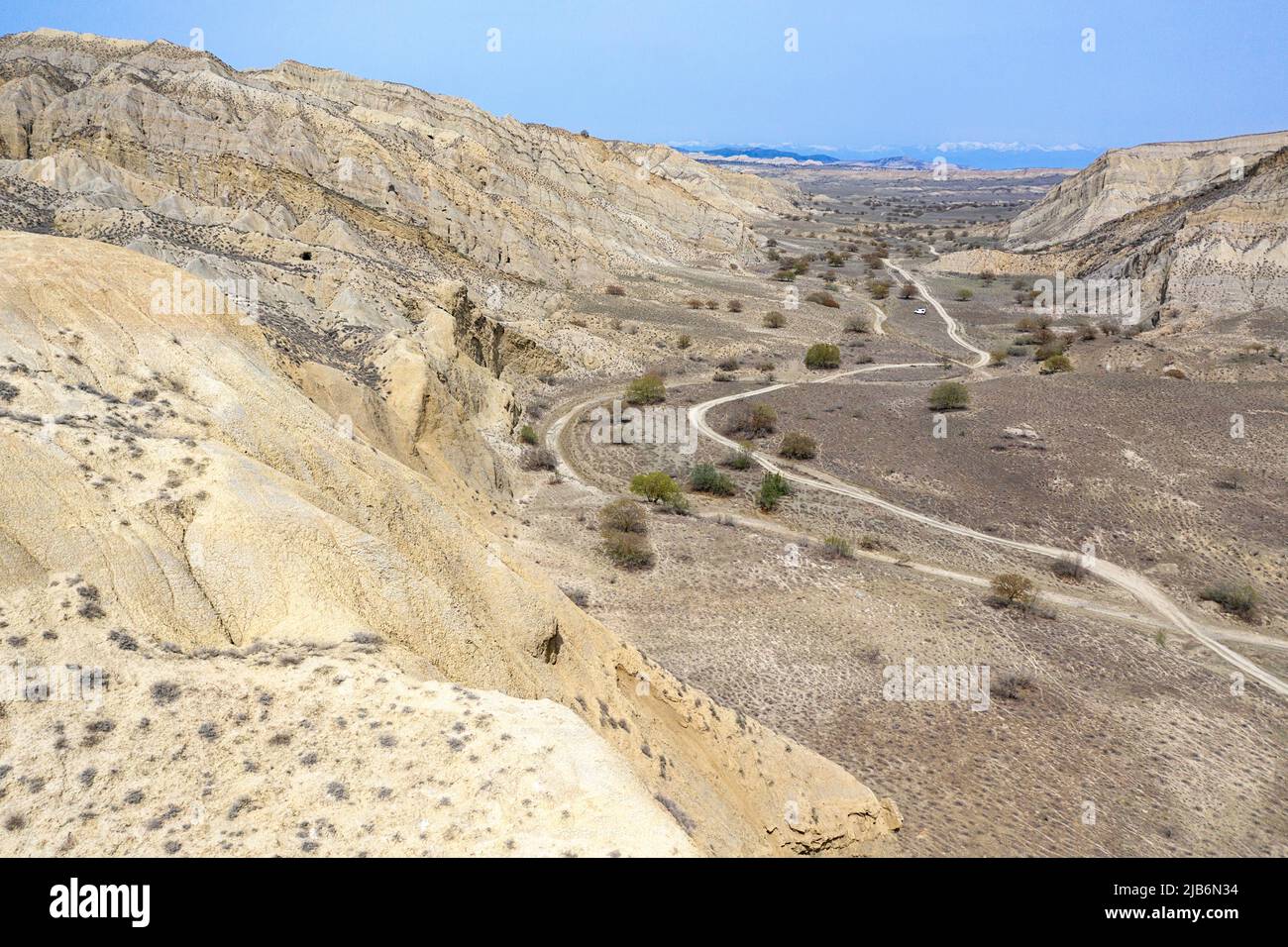 Gravel road winding through spectacular desert like landscape in ...