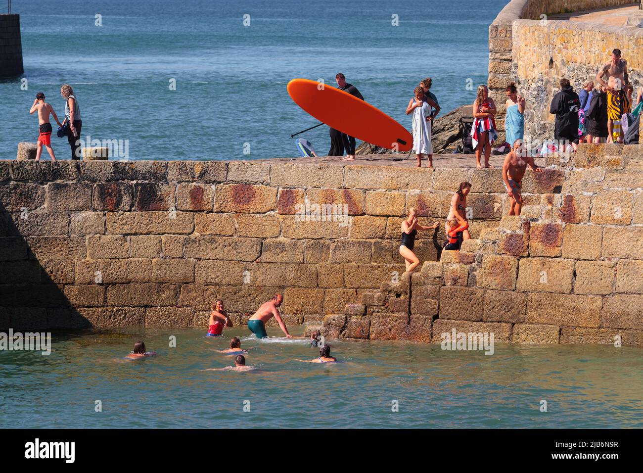Sea swimming and paddleboarding off the harbour wall at Porthleven ...