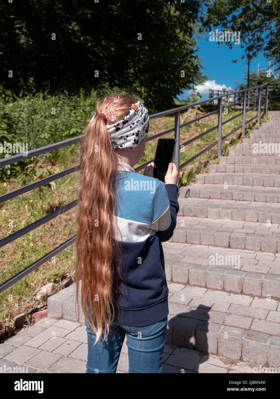 Adorable child girl with long hair chatting in social media smartphone ...