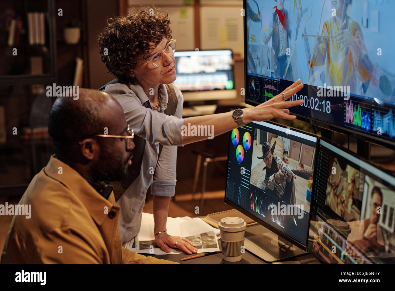 Project manager pointing at big display and giving instructions to ...