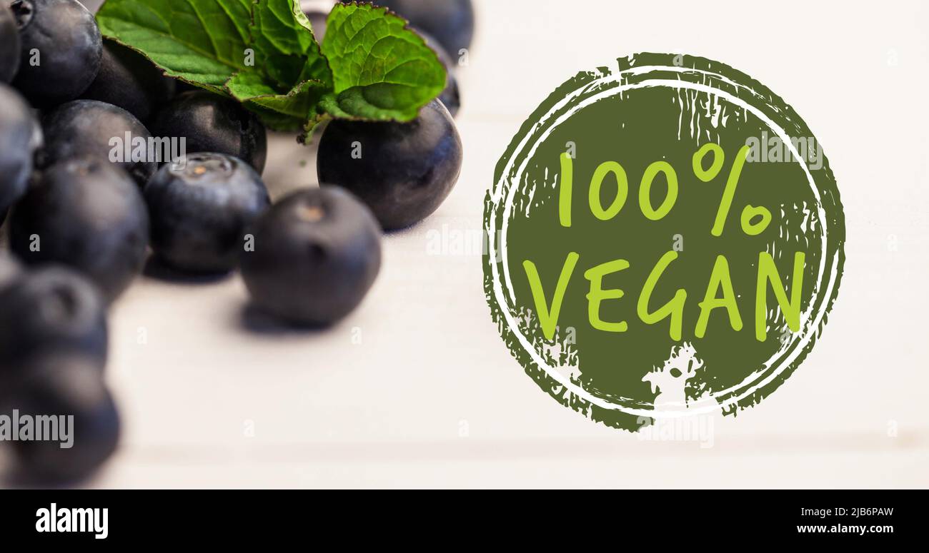 Image of 100 percent vegan text in green over fresh organic blueberries ...