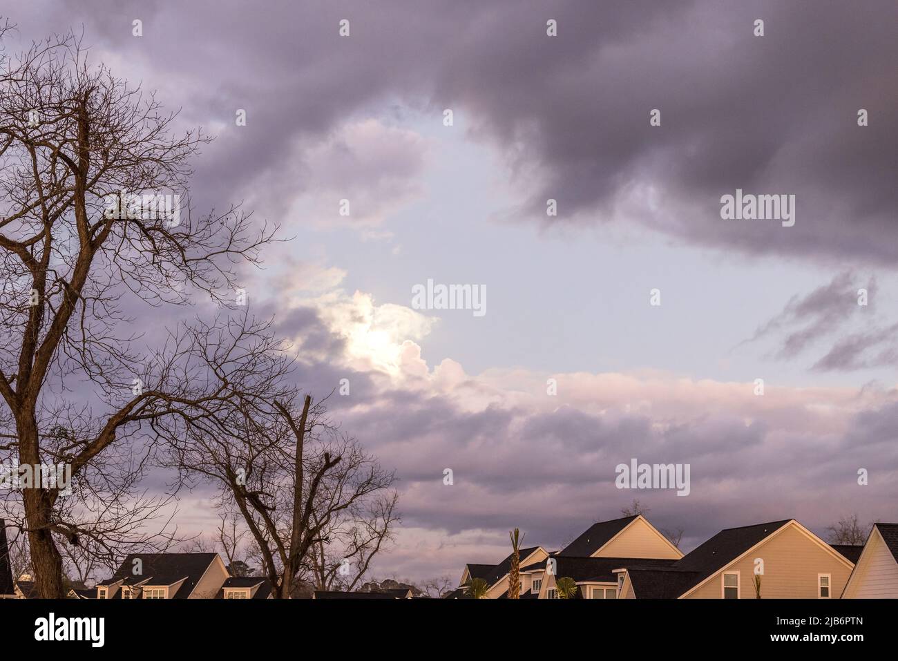 A dark and gloomy sky before a rainstorm with the sun peeking out over ...