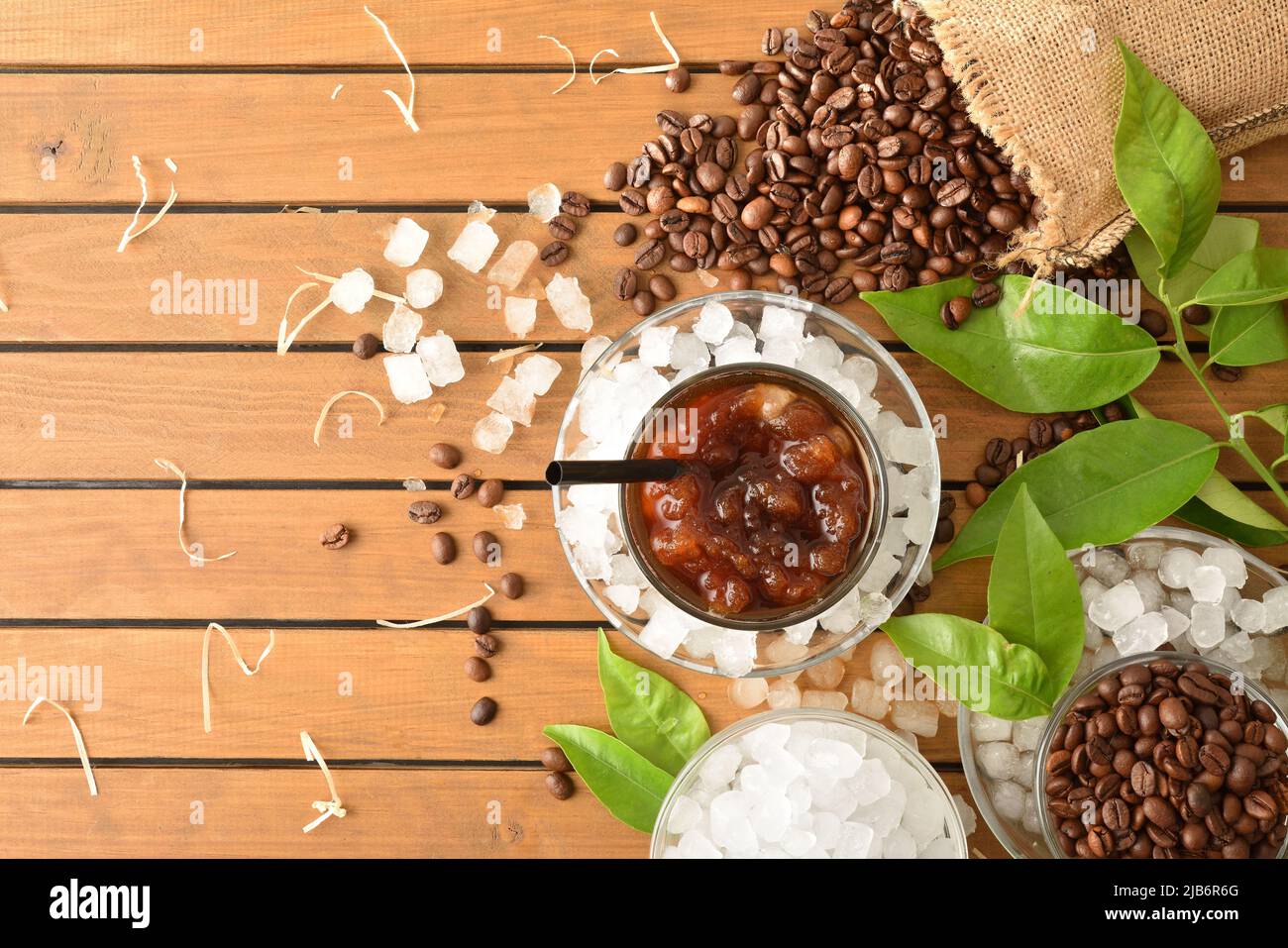 Natural iced coffee on wooden table with crushed ice and coffee beans ...
