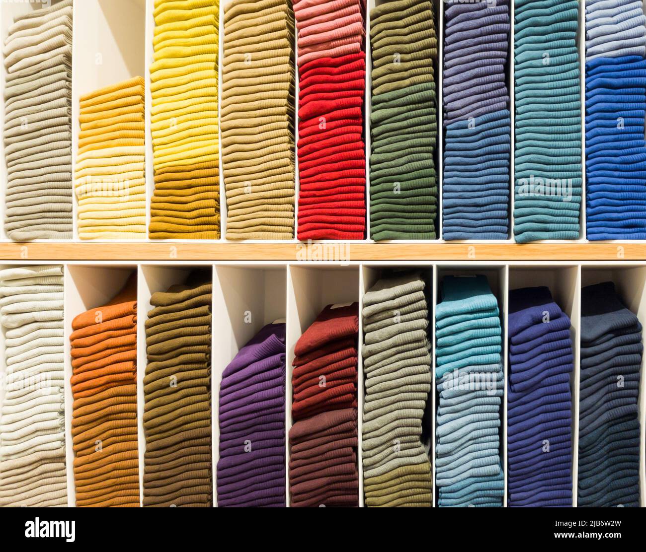 The colourful socks are arranged on the shelf for sale in a shopping ...