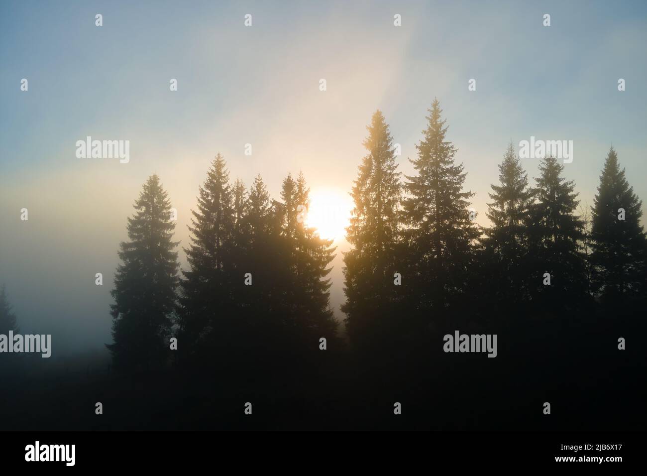Aerial view of amazing scenery with light beams shining through foggy ...