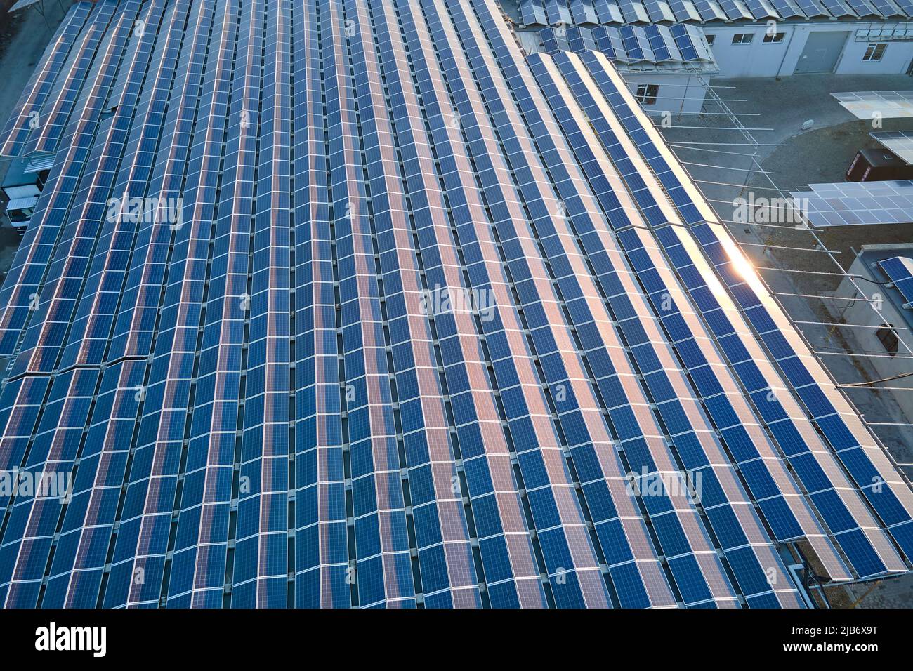 Aerial view of blue photovoltaic solar panels mounted on industrial ...