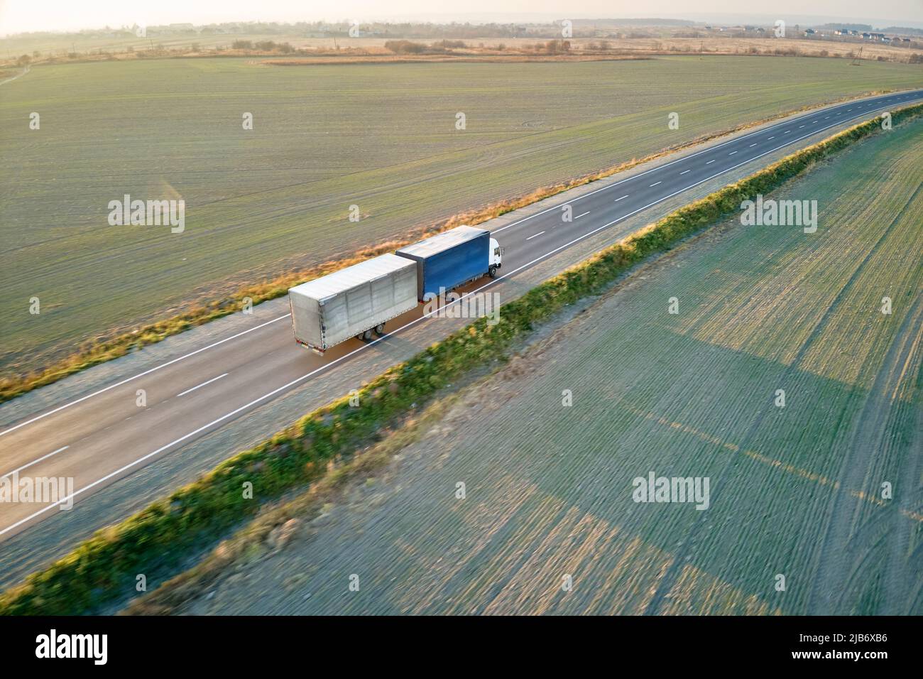 Aerial view of blurred fast moving semi-truck with cargo trailer ...
