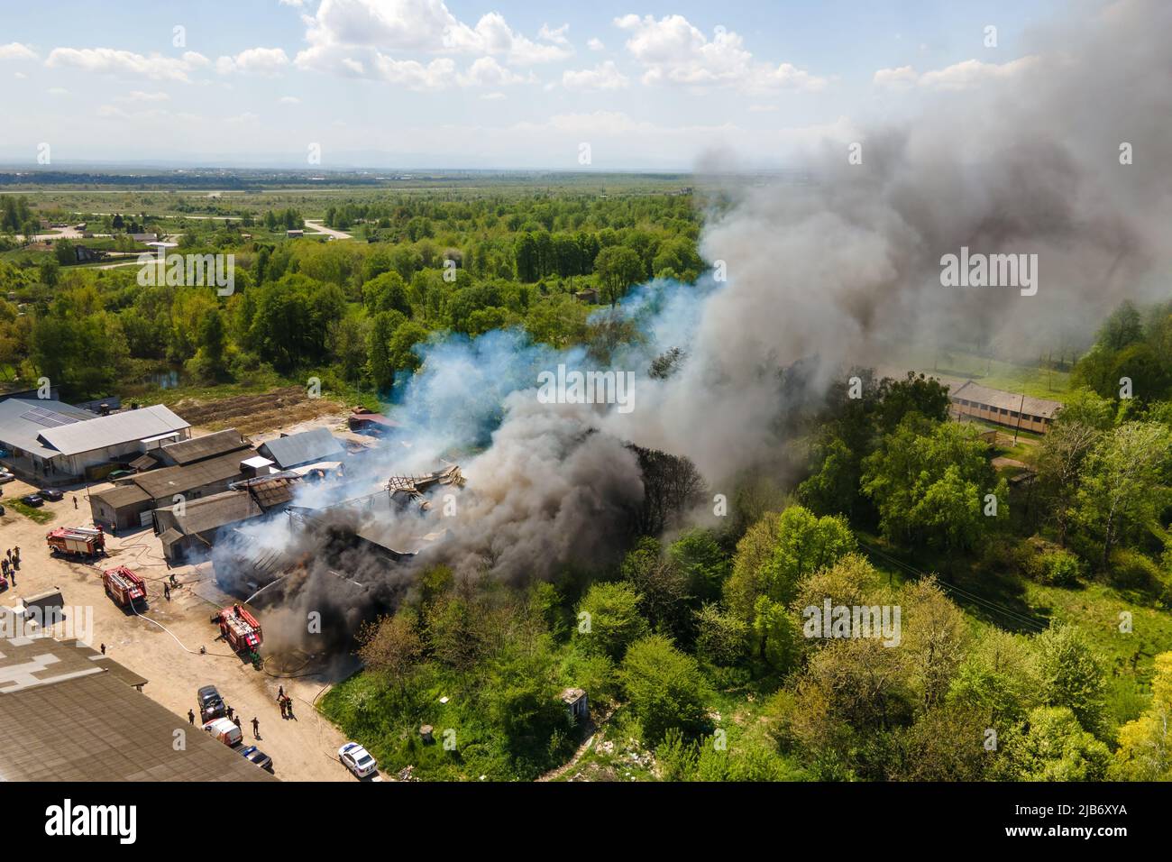 Aerial view of firefighters extinguishing ruined building on fire with ...