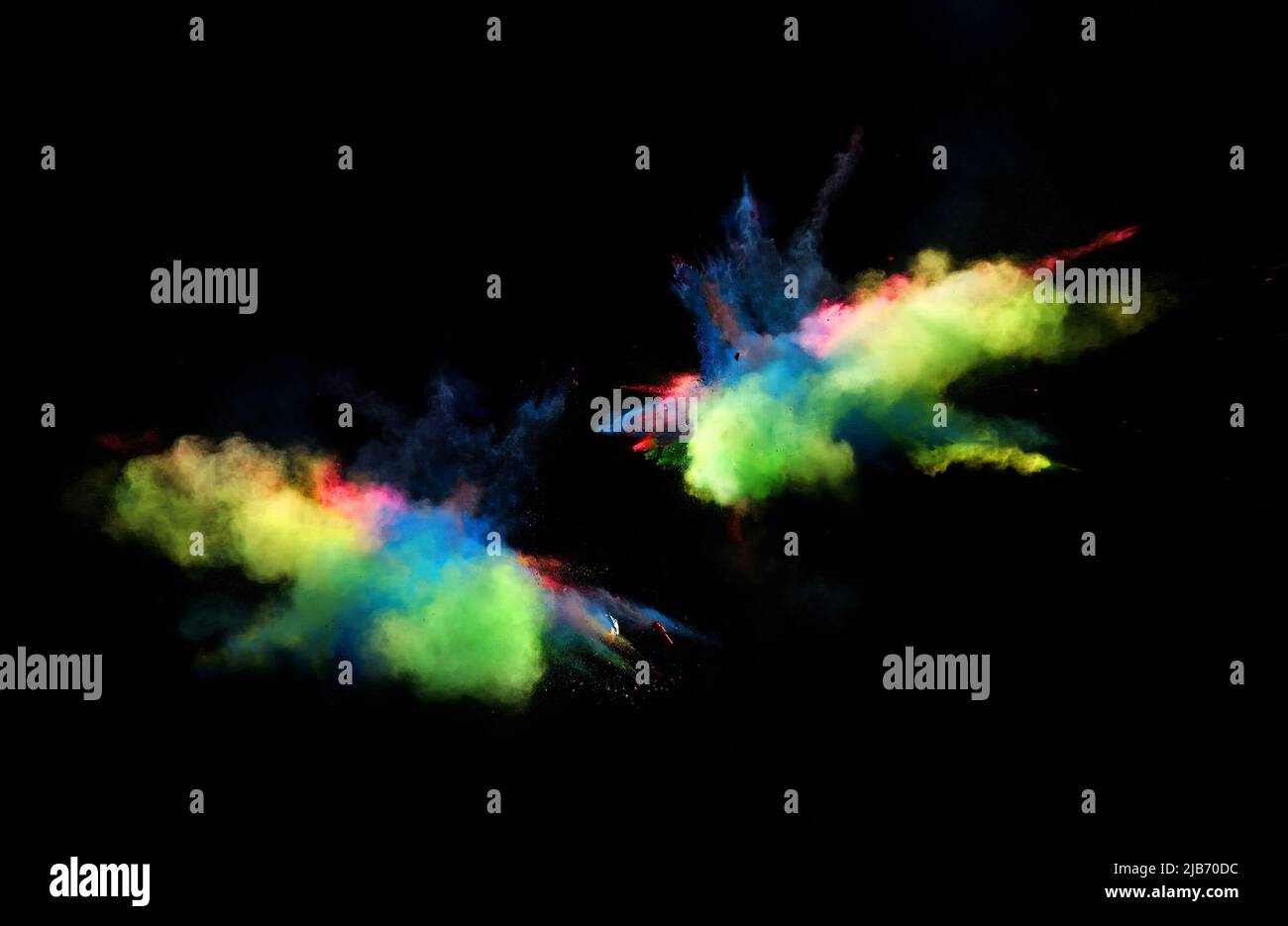 Various multicolored forms of powder paint explode in front of a black ...