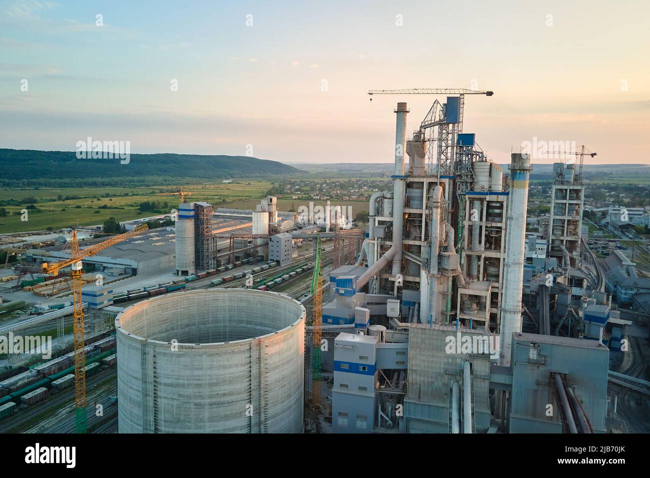 Cement plant with high factory structure and tower cranes at industrial ...