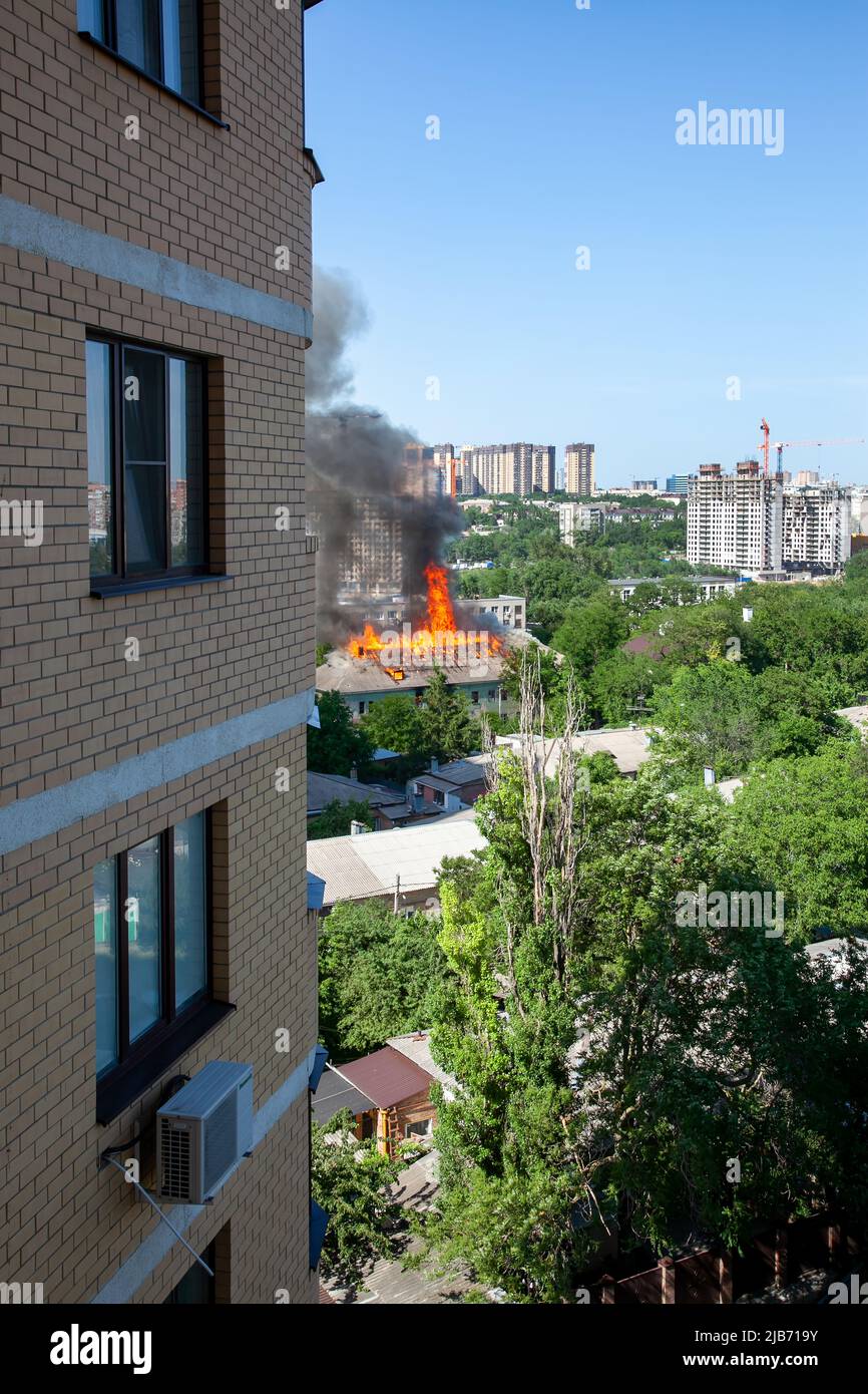 Old and new. An old abandoned building is burning against the ...