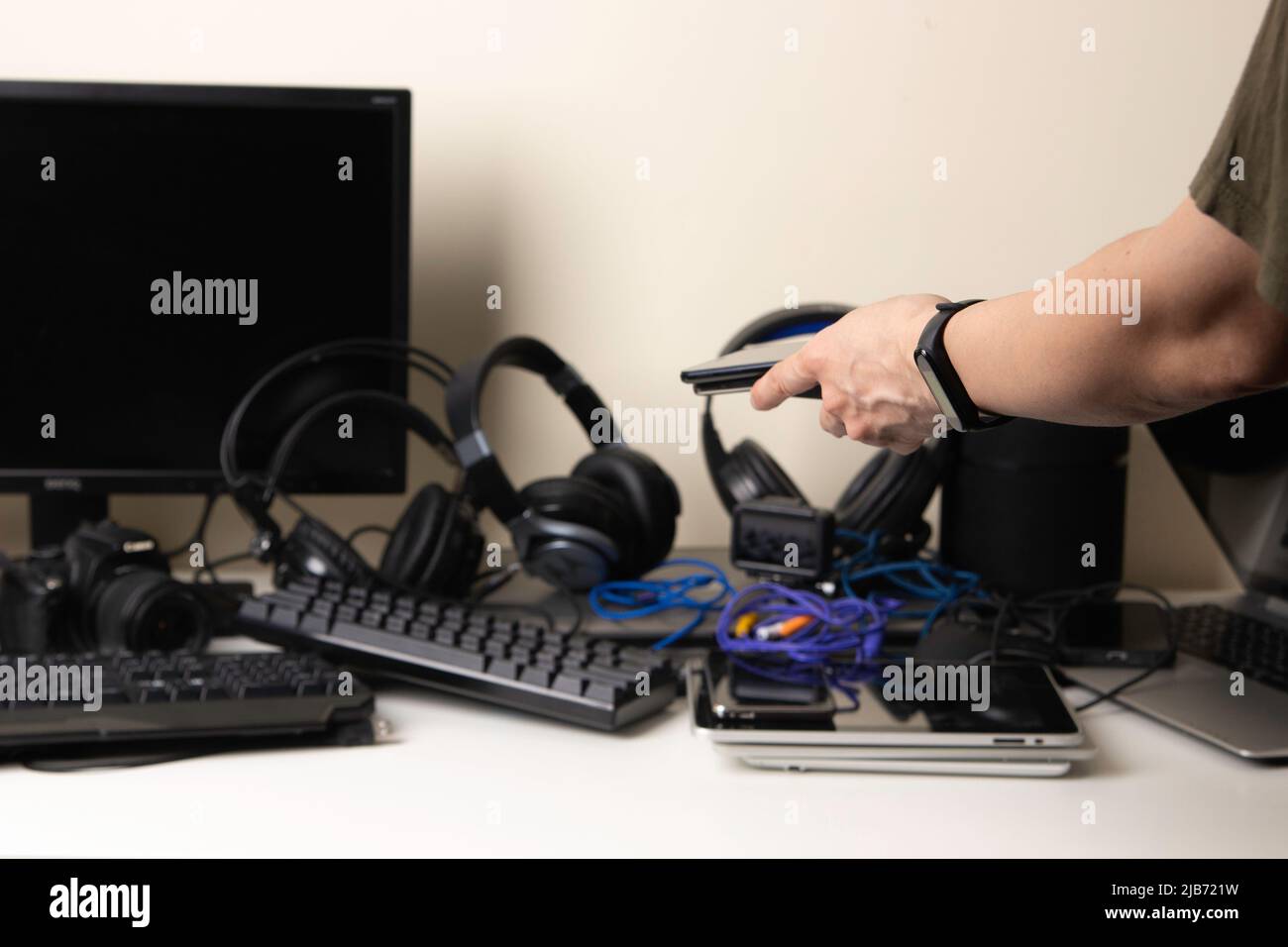Woman hands put mobile cell phones on pile of old used computers and ...