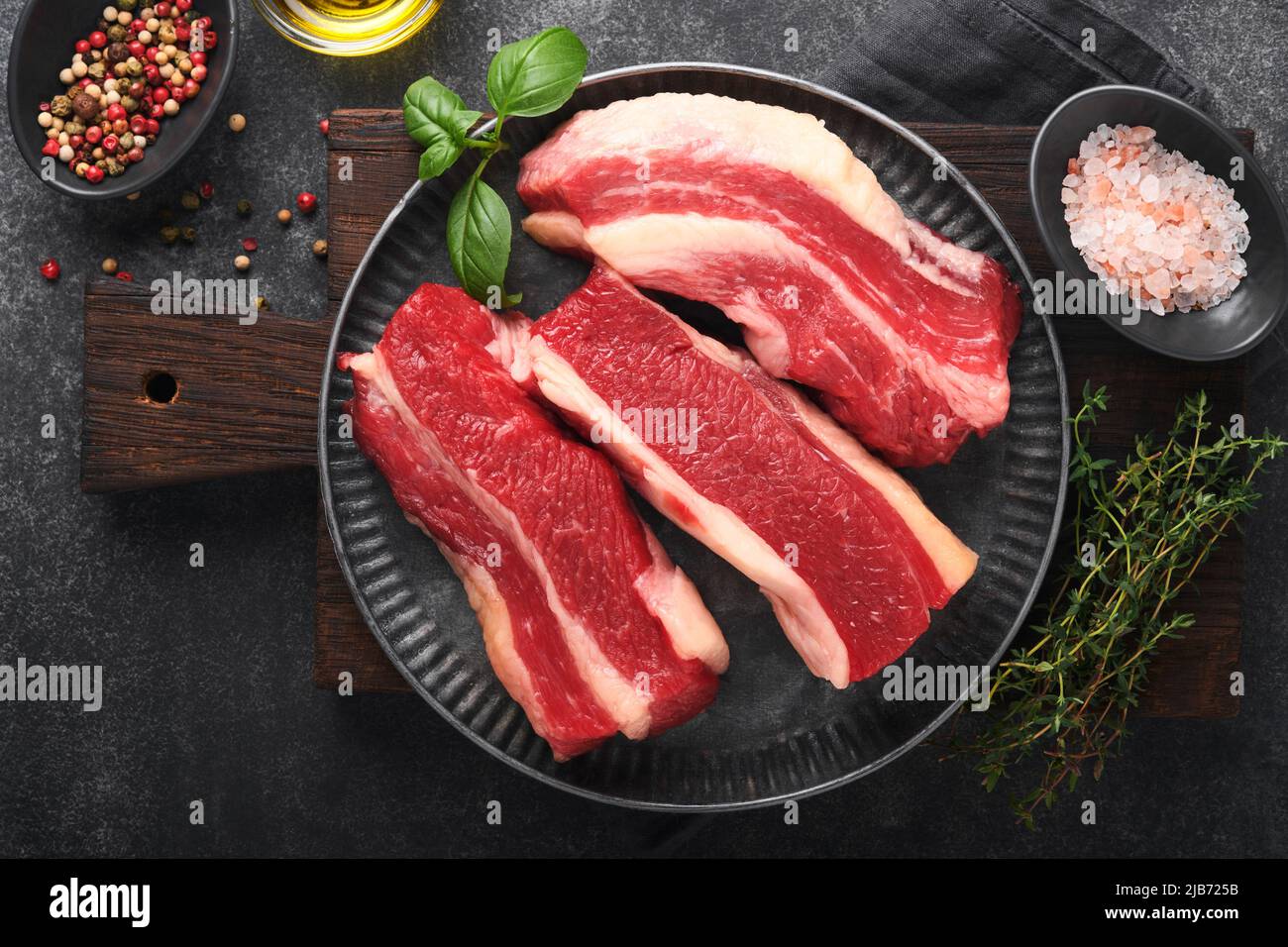 Steak beef. Raw steak New York with rosemary and spices on old iron ...