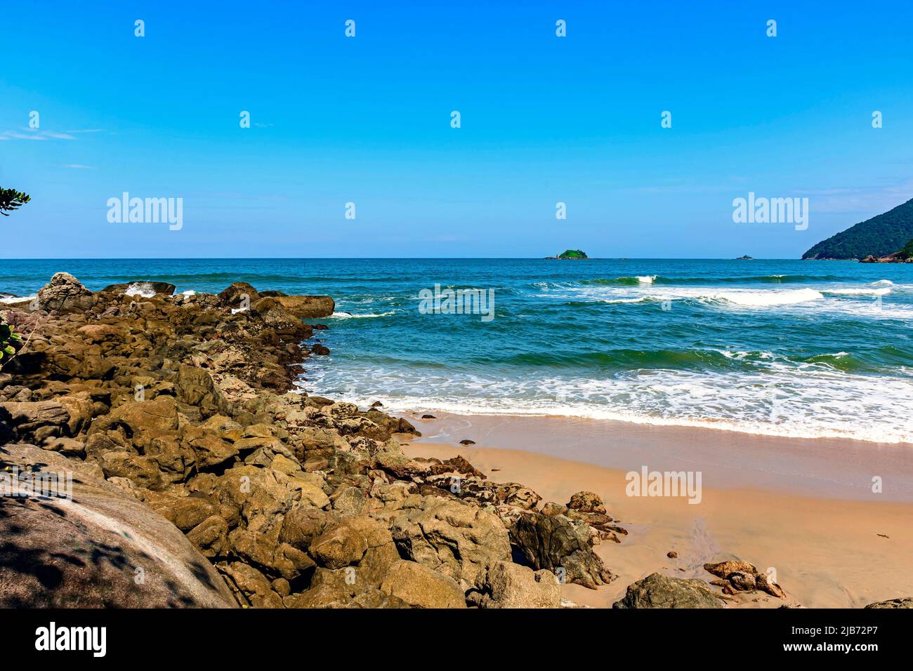 Paradisiacal rocky beach with clean and calm waters in Bertioga coastal ...