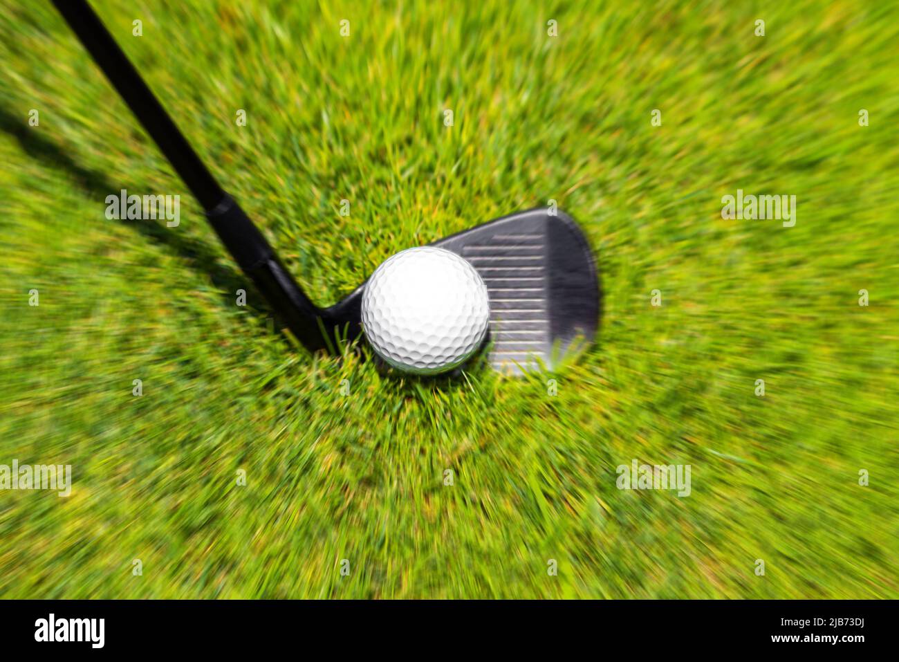 Closeup of hitting golf ball with golf iron club golf course wih motion ...