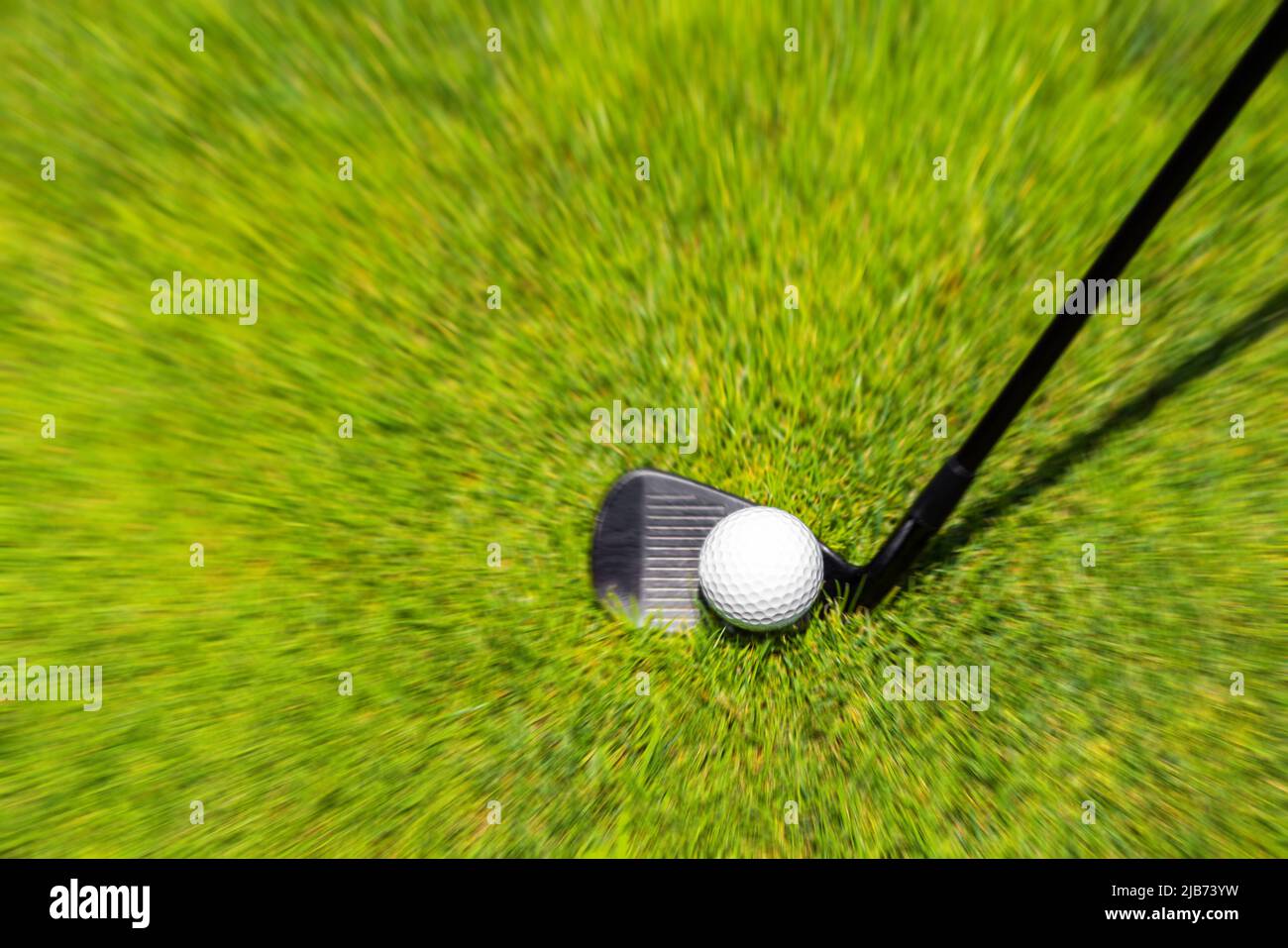 Closeup of hitting golf ball with golf iron club golf course wih motion ...