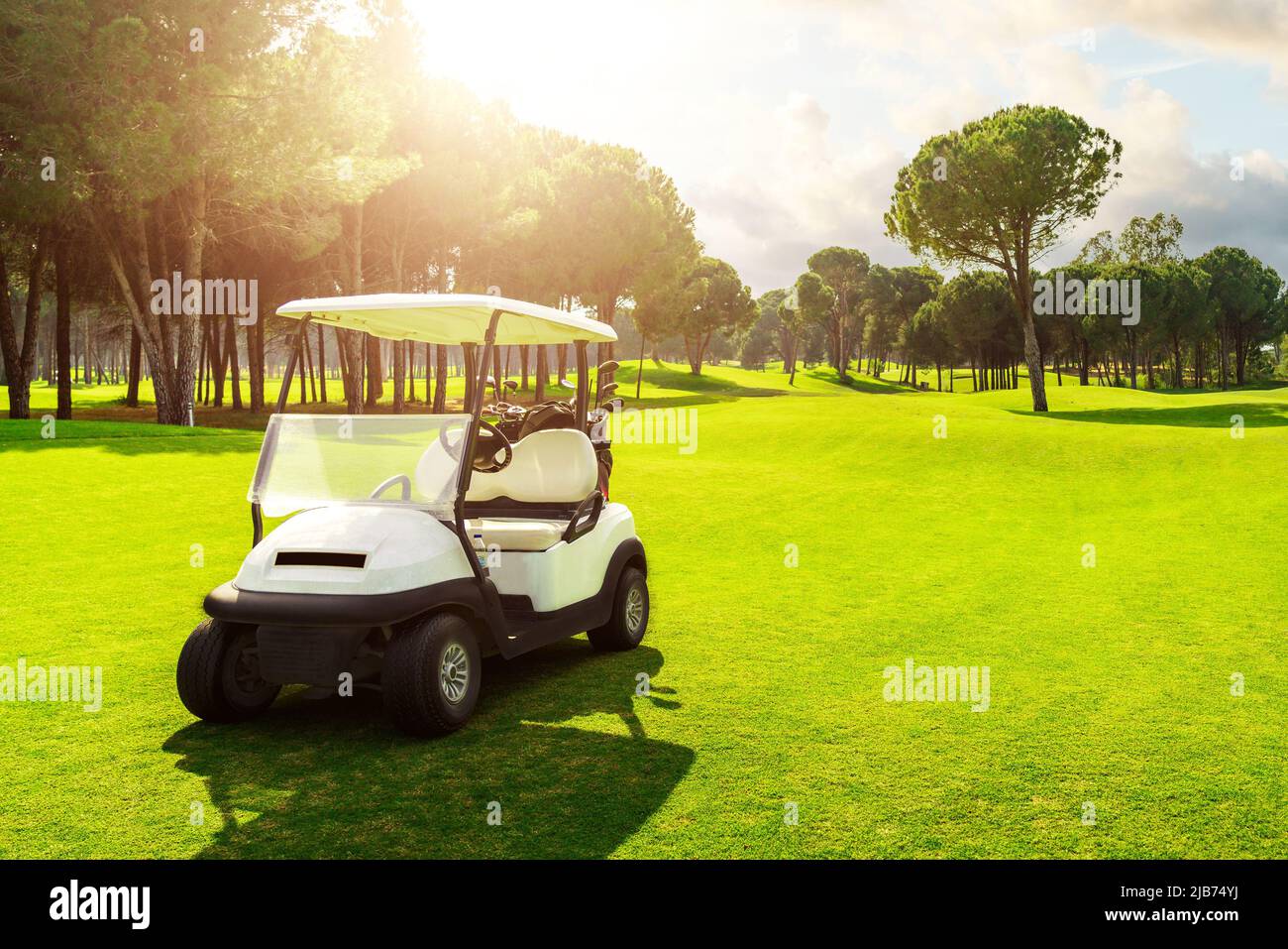 Golf cart in fairway of golf course with green grass field with cloudy ...