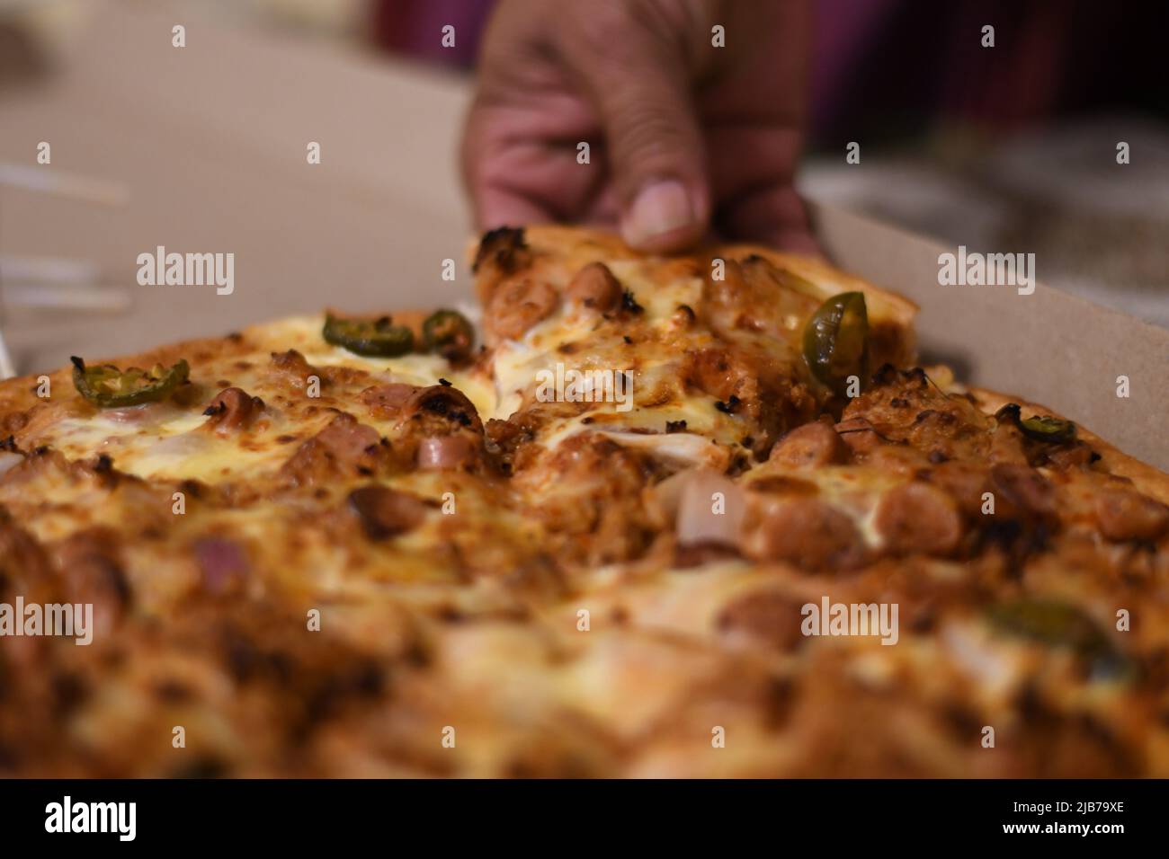 Slice of Pizza is being taken out Stock Photo - Alamy
