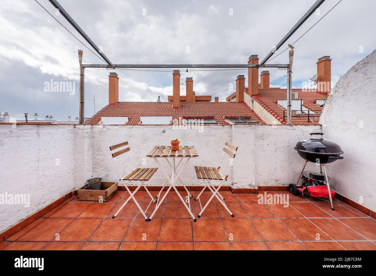 Terrace of a house with a wooden and metal table, matching chairs and a ...