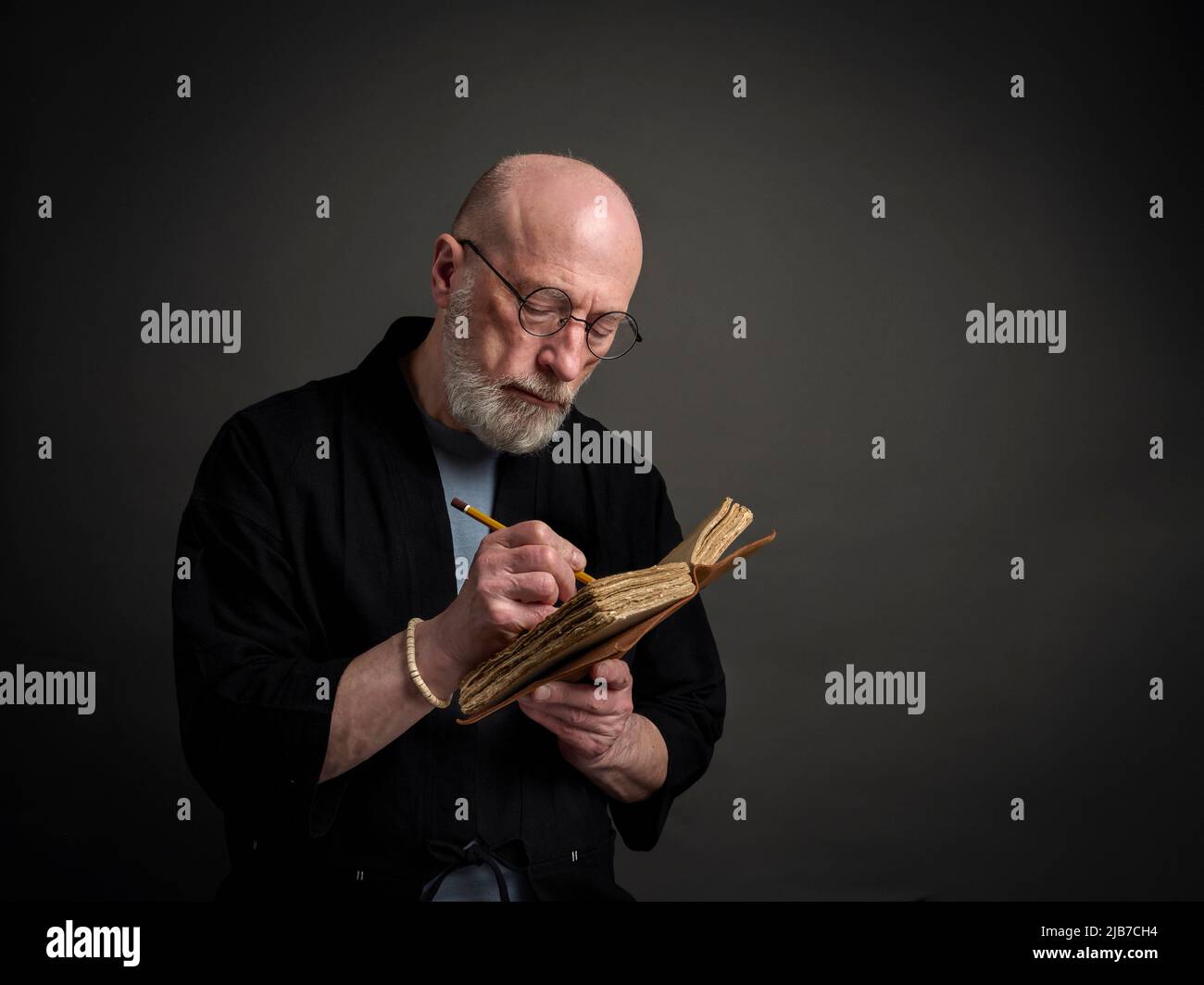 Head and shoulders portrait of bald and bearded senior man in kimono ...