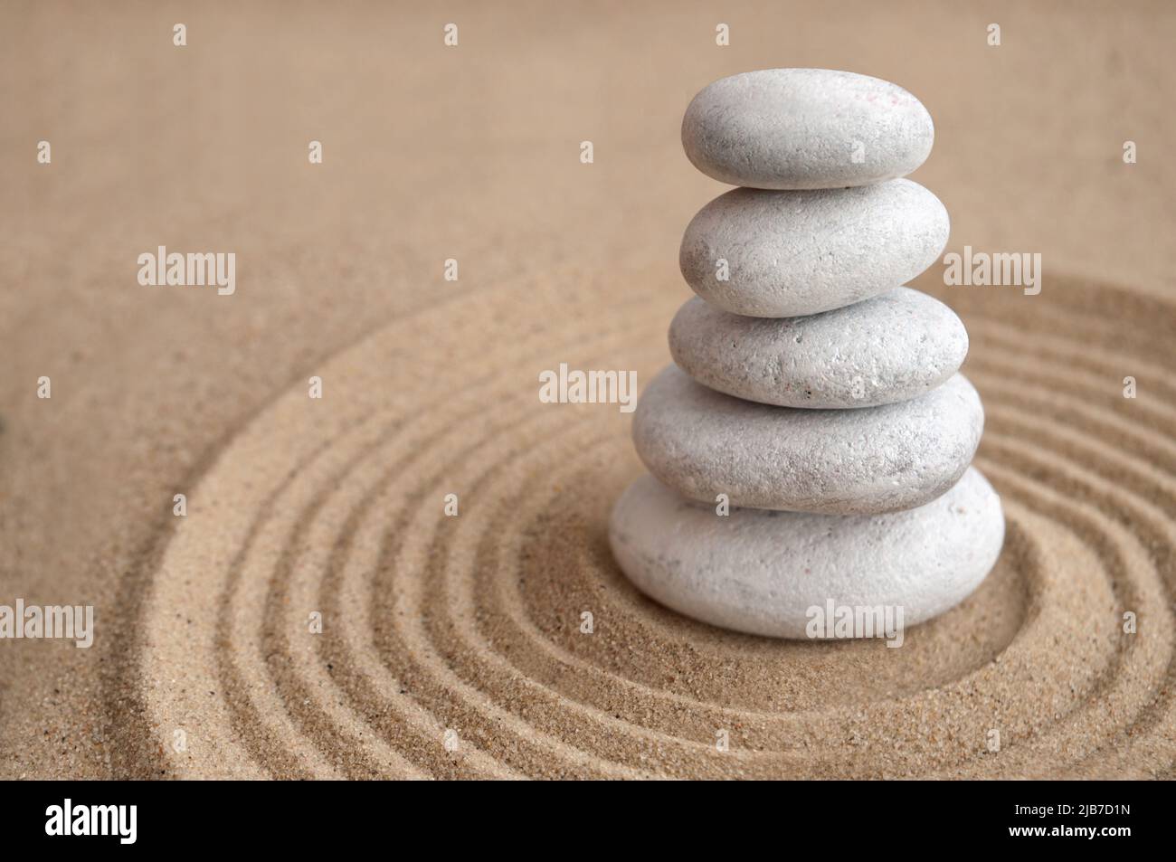 Yoga zen stones balanced on top of one another inside a sand circle ...
