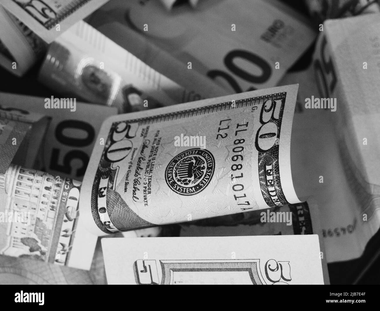 Cash banknotes dollars and euros are mixed up, a close-up shot. Black ...