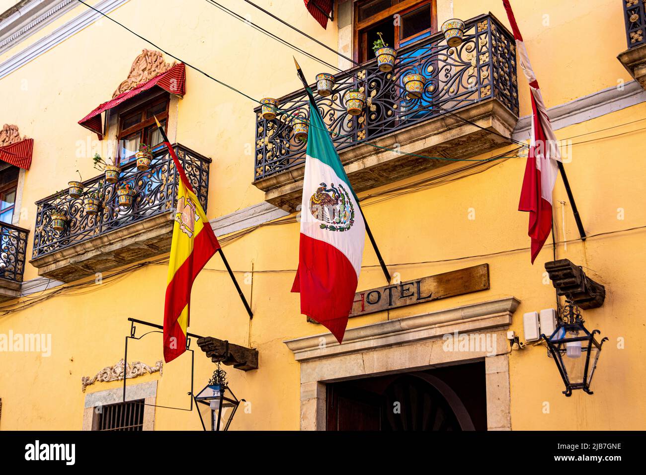 Three flags, including the Mexican flag in the middle, mounted on a ...