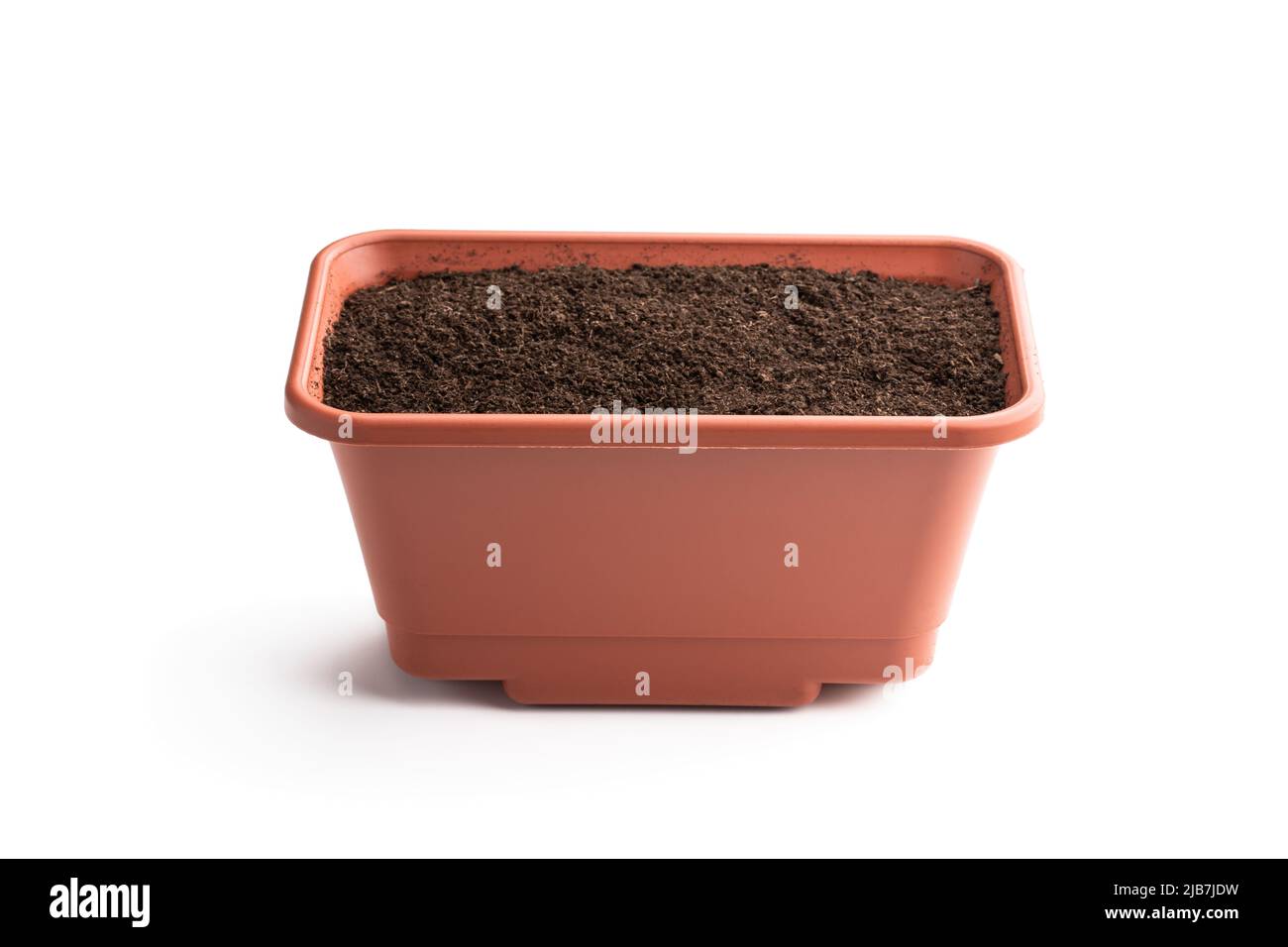Rectangular pot filled with organic potting soil isolated on white ...