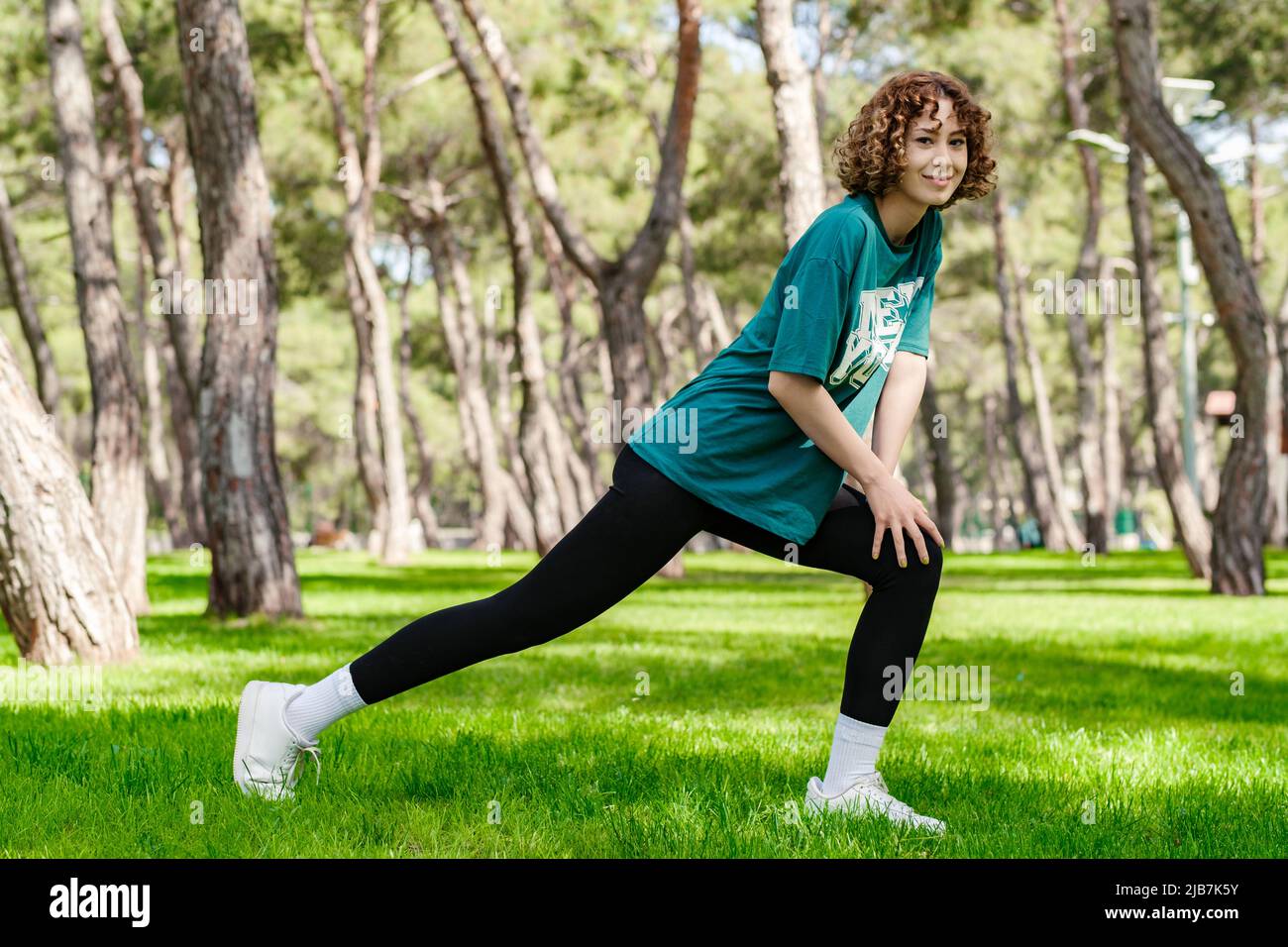 Full Length Shot Of Young Redhead Woman Wearing Green T Shirt And Black