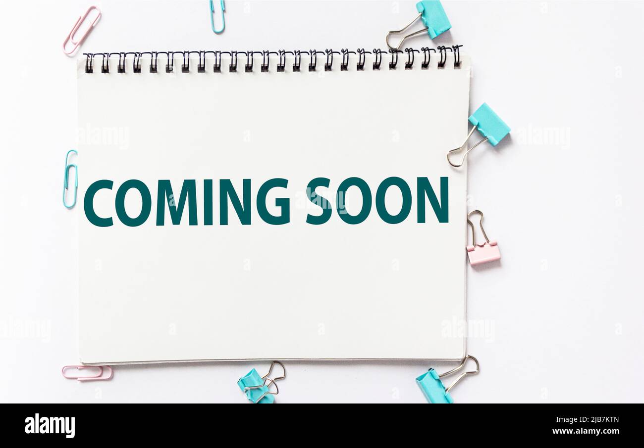 Text in notepad COMING SOON on a white background with multi-colored ...