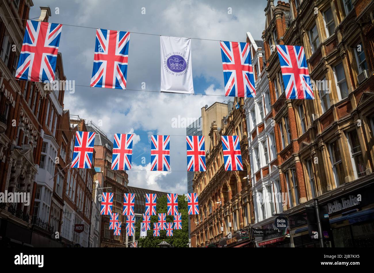Colourful bunting showing the union flag is hung over a street in ...