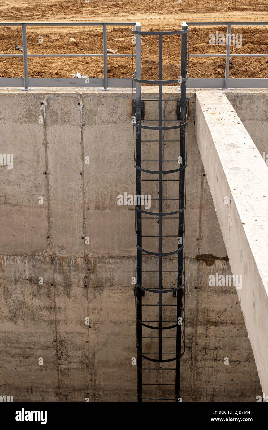 The steel stair on the concrete wall of the well Stock Photo - Alamy