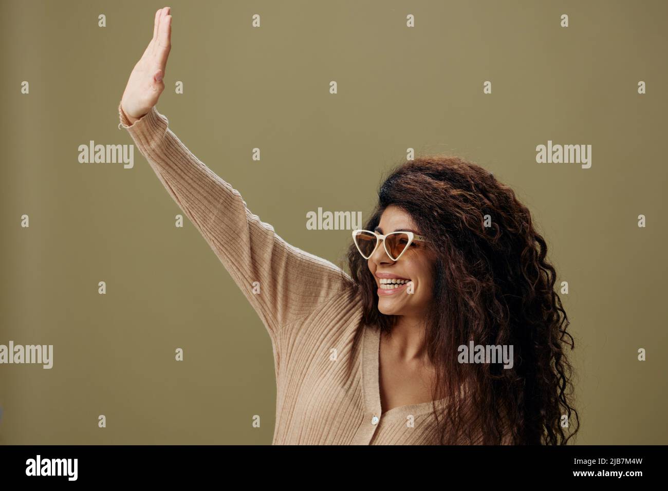 SUNSHINE CONCEPT. Happy enjoyed tanned curly Latin female in casual ...