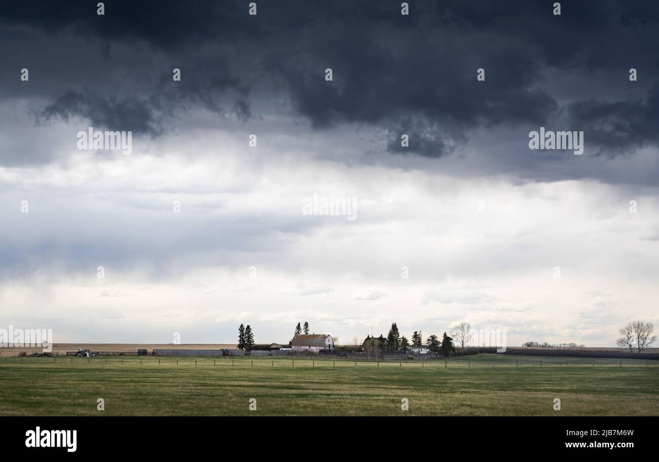 A hail storm forms above a country homestead on the Canadian prairies ...
