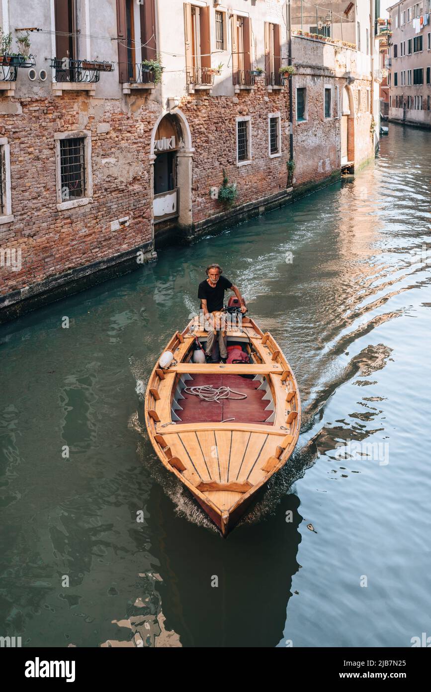 Venice, Italy - May 21, 2022: Local Italian man with a dog driving a ...